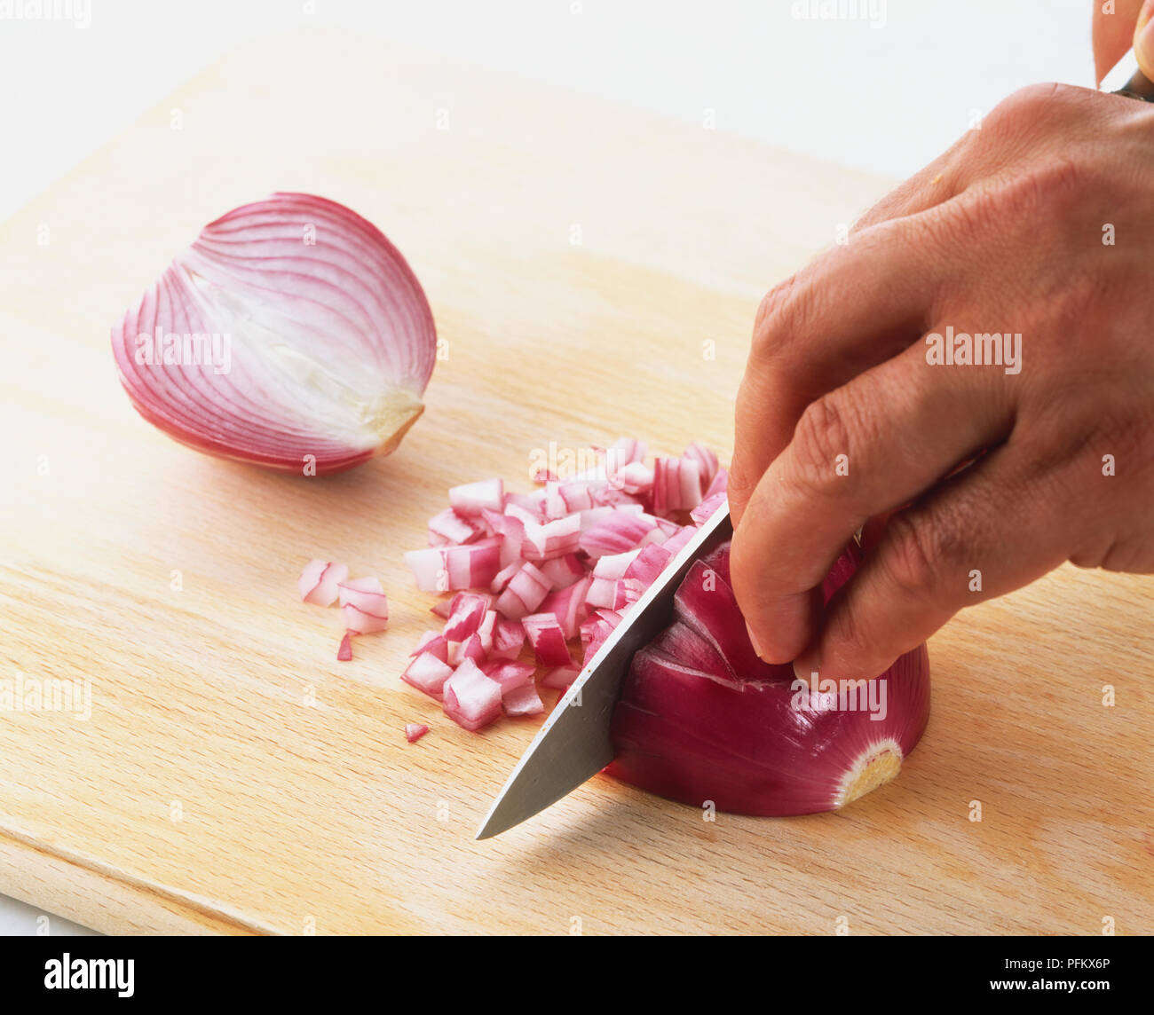 Cutting a red onion crosswise and dicing, using a sharp knife Stock ...