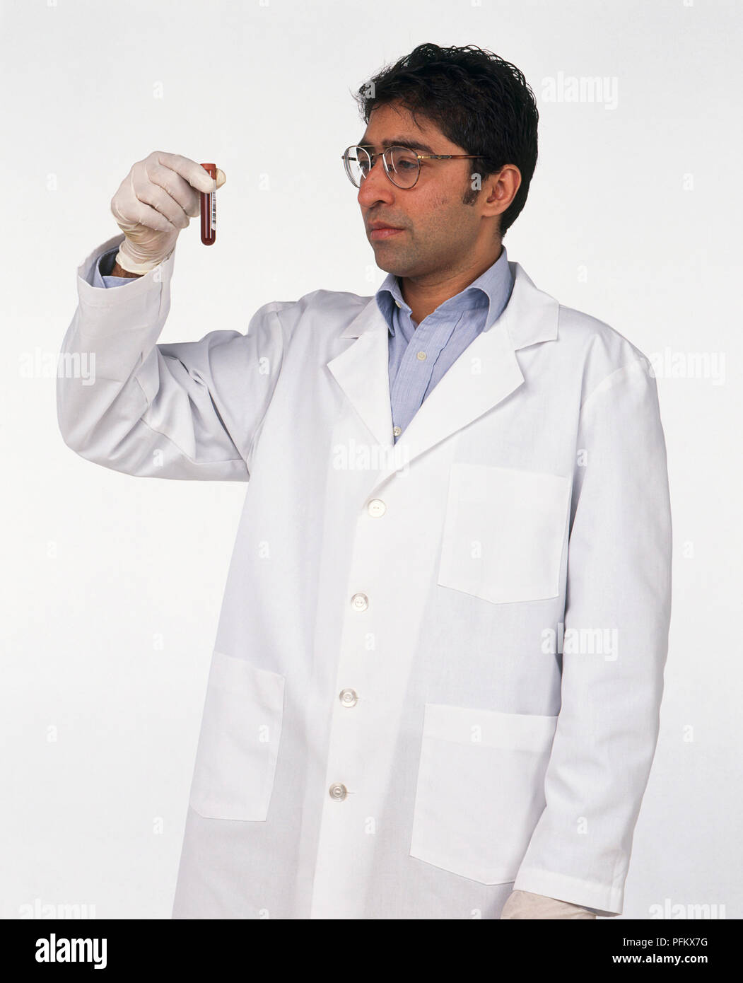 Doctor in laboratory coat holding up a phial of blood Stock Photo - Alamy