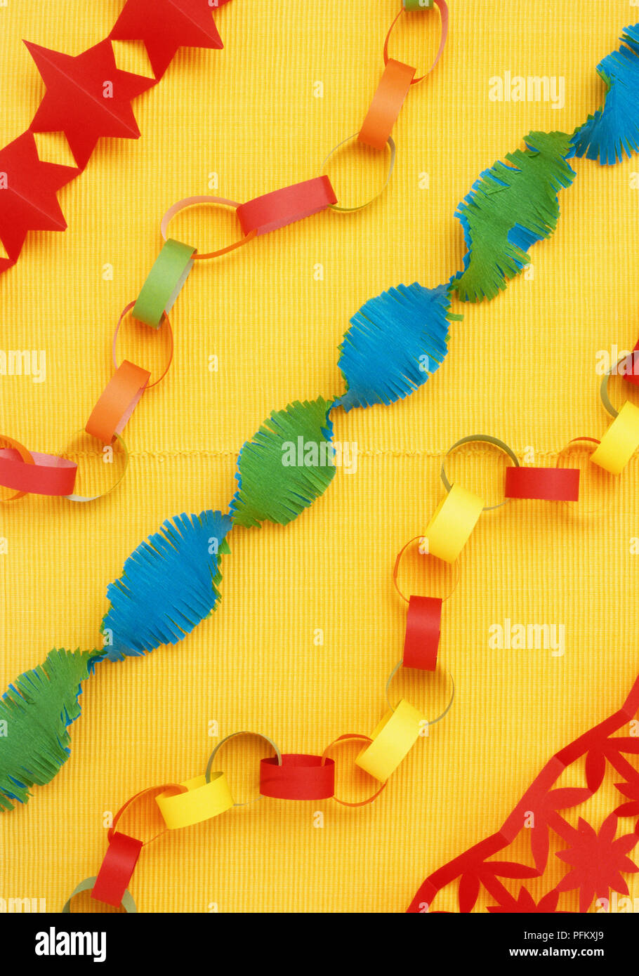 Paper chains, streamers and concertina decorations on a yellow ...