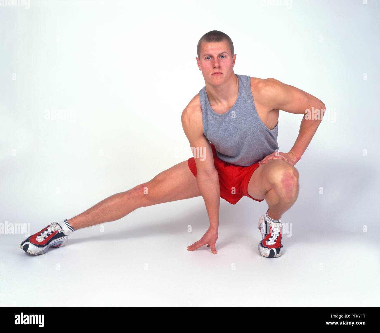 Young male athlete stretching hamstring Stock Photo - Alamy
