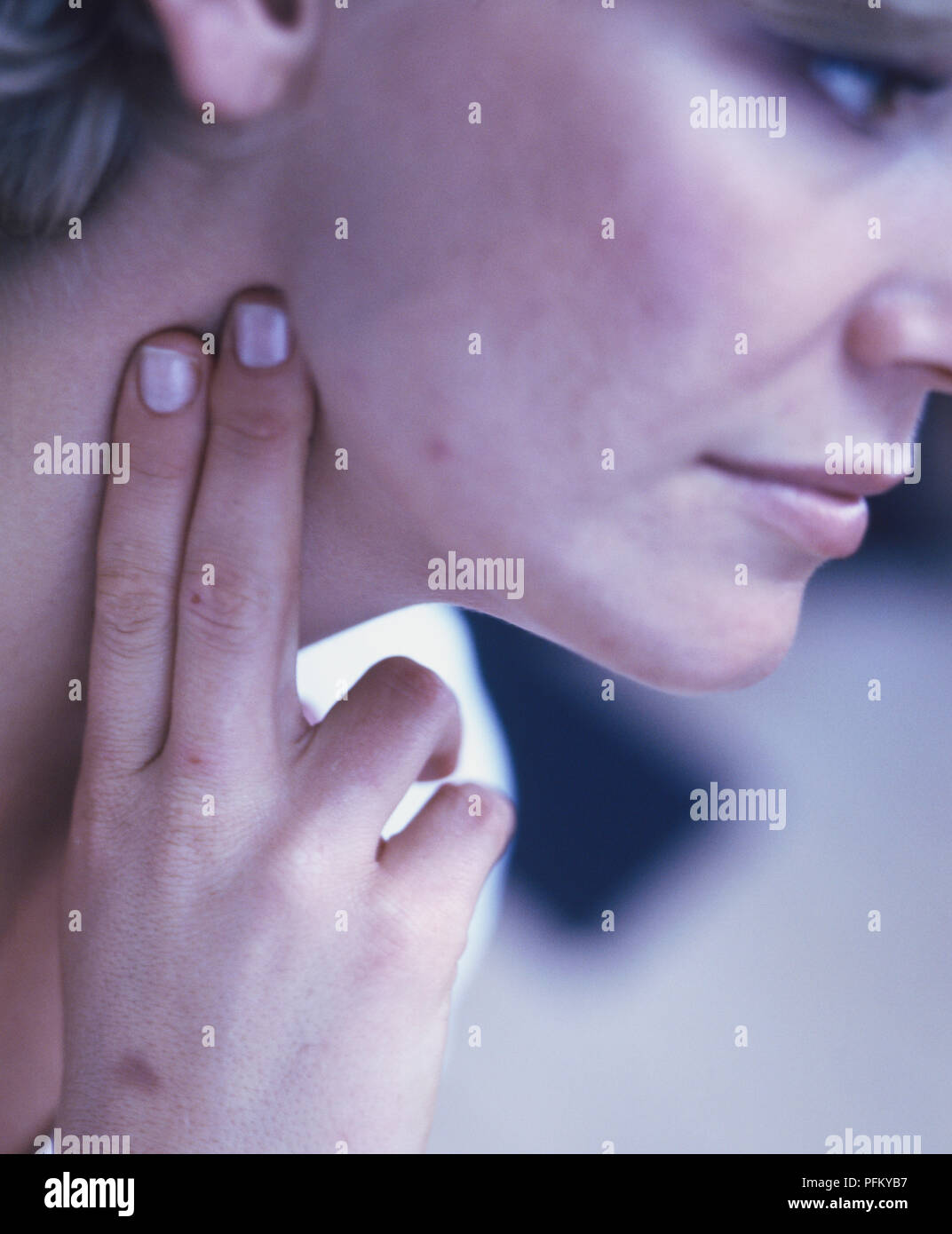 Woman using two fingers to feel pulse at side of her neck, below ...