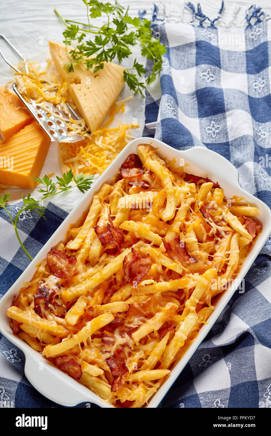 aussie fries smothered in melted cheese and bacon in a baking dish on a ...