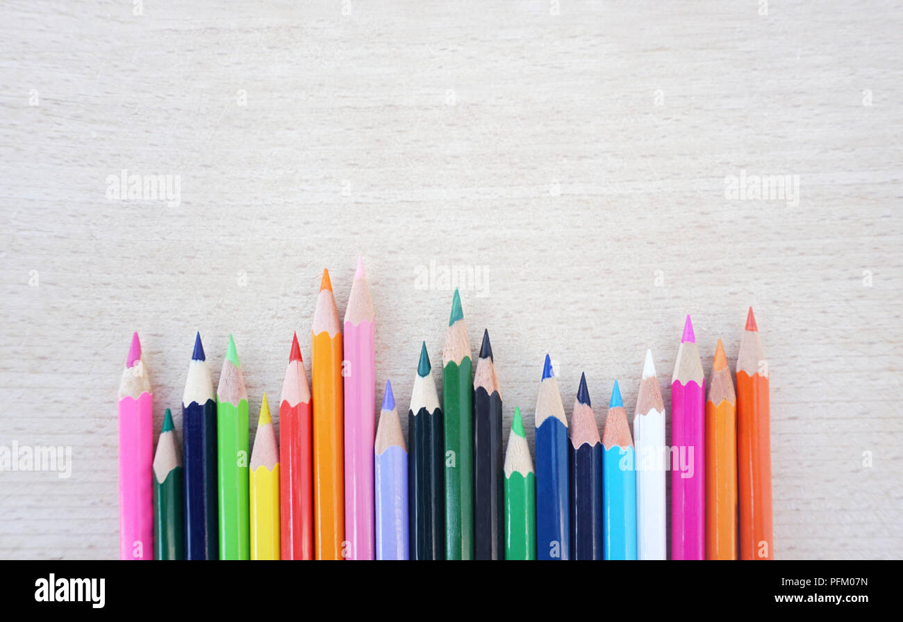 Wooden crayons, pencils in different colors lined flat lay and down on ...