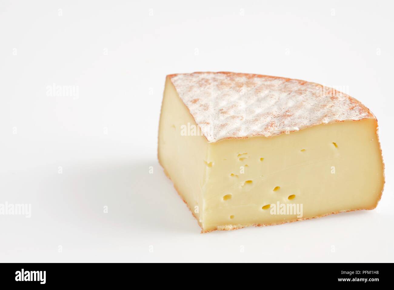 Slice of French Pavin cow's milk cheese Stock Photo - Alamy