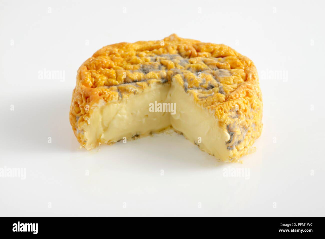 Round of Plaisir au Chablis cow's milk cheese with wrinkled yellow rind ...