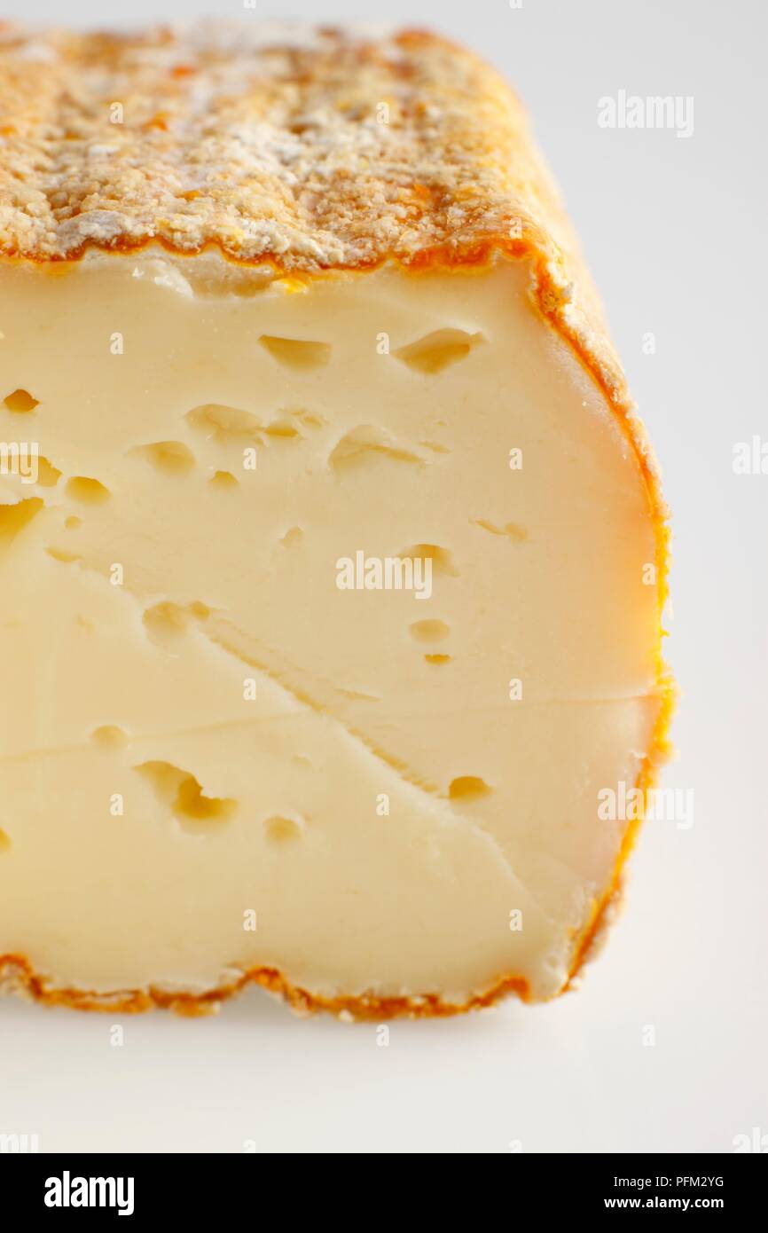 Slice of French Sable de Wissant cow's milk cheese with orange rind ...