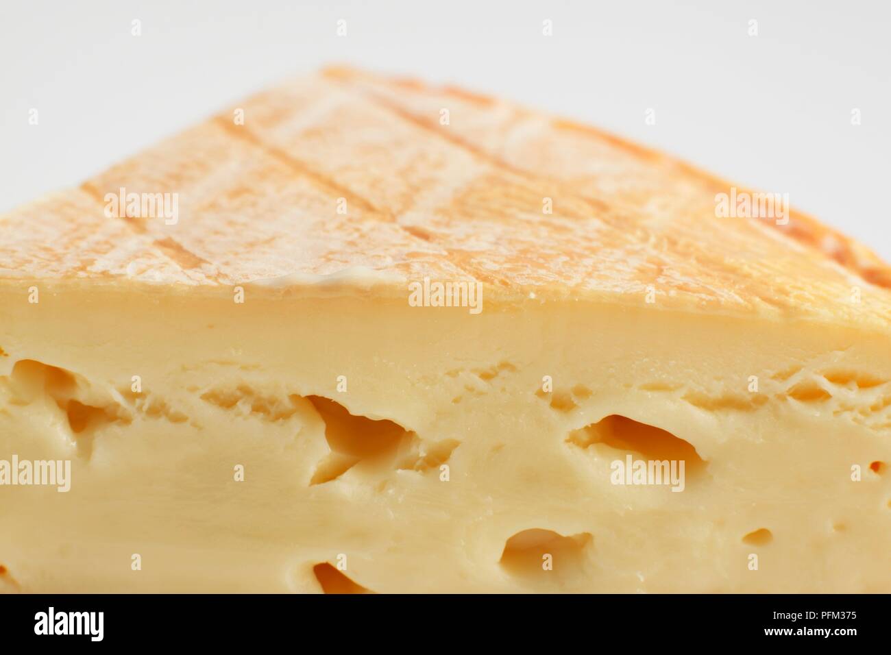 Slice of French Munster AOC cow's milk cheese Stock Photo - Alamy