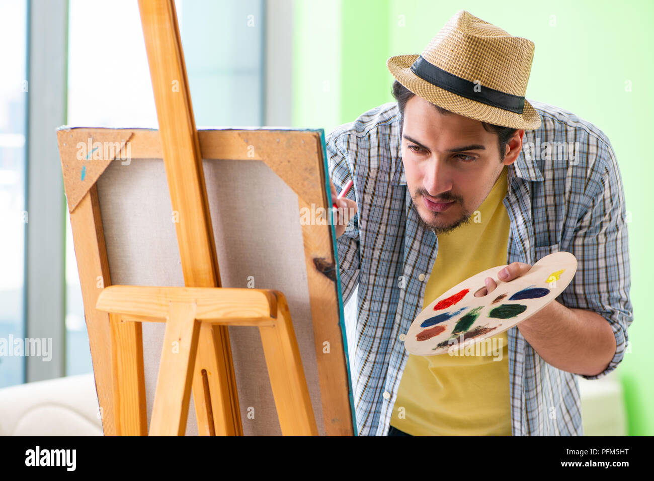 Young male artist working on new painting in his studio Stock Photo - Alamy
