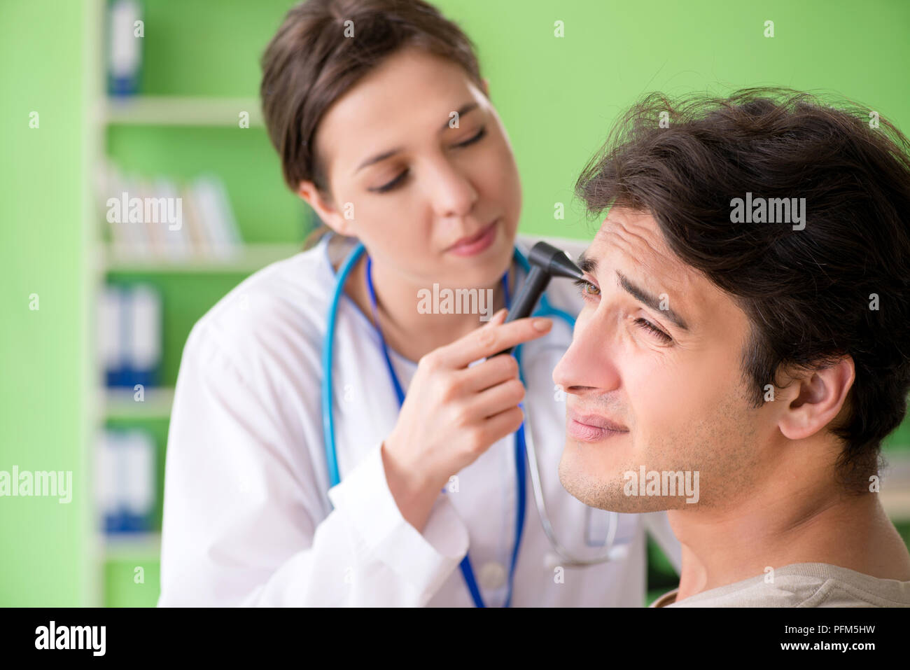 Female doctor checking patient's ear during medical examination Stock ...