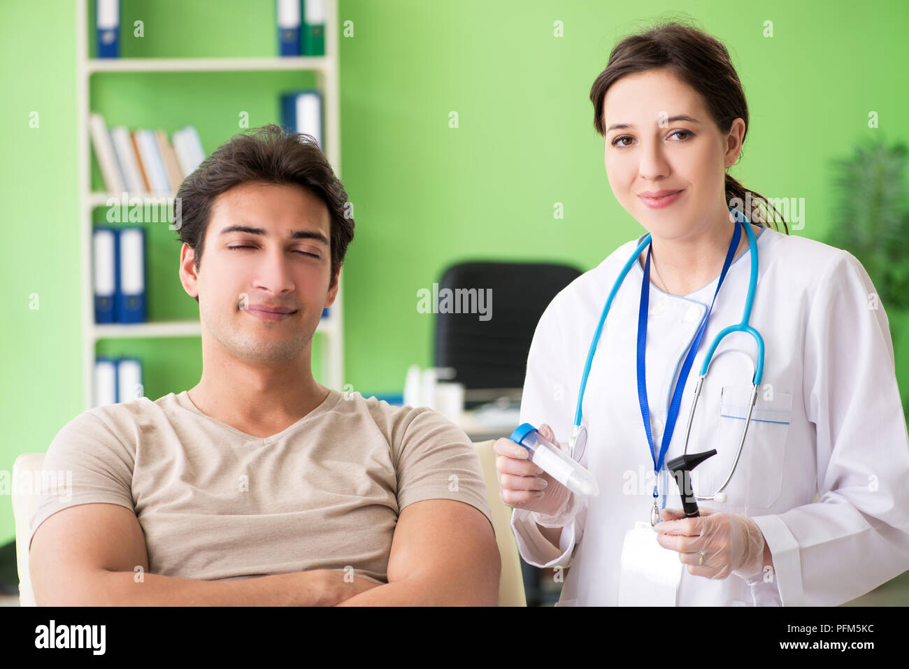 Female doctor checking patient's ear during medical examination Stock Photo - Alamy