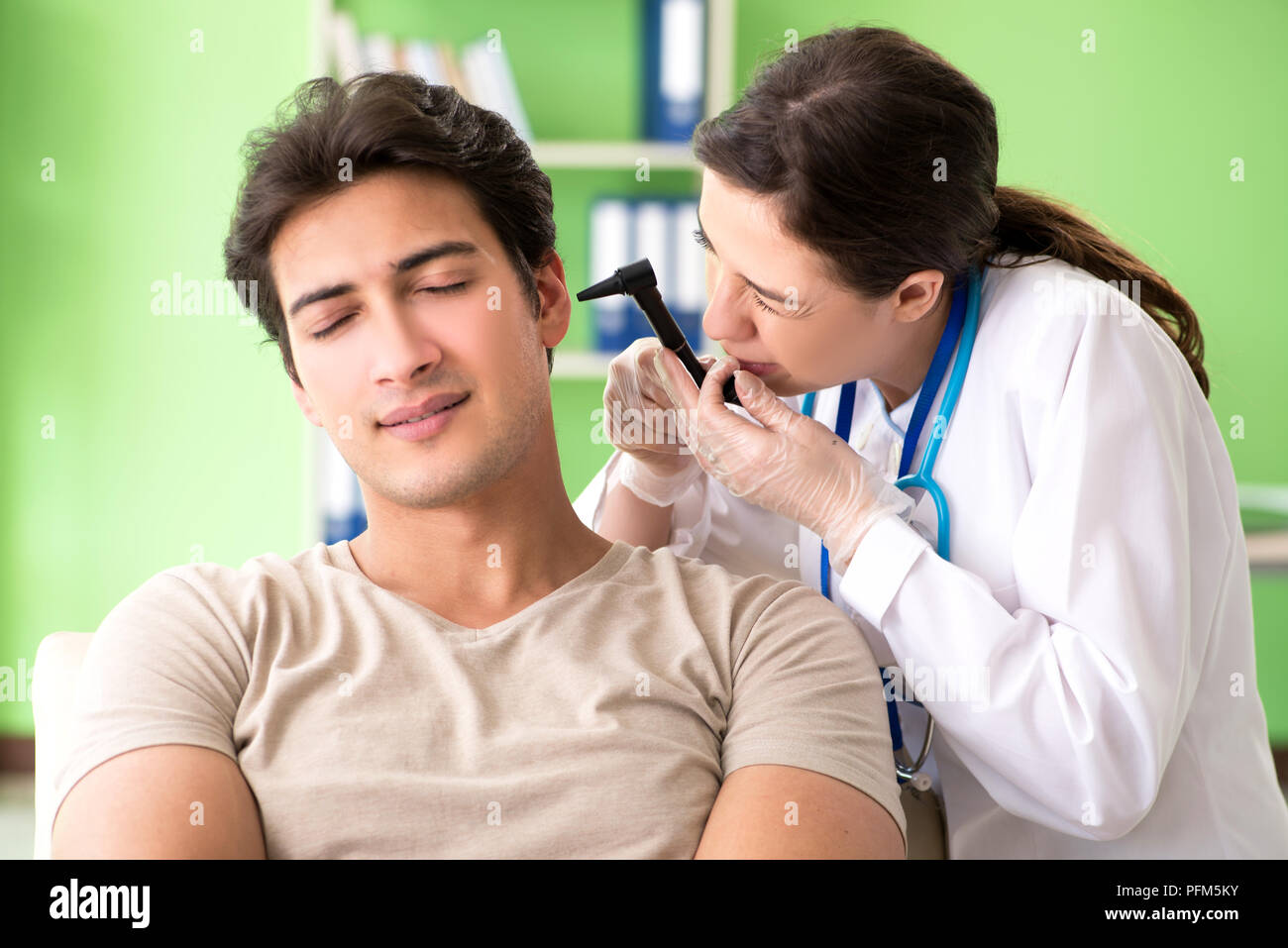 Female doctor checking patient's ear during medical examination Stock ...