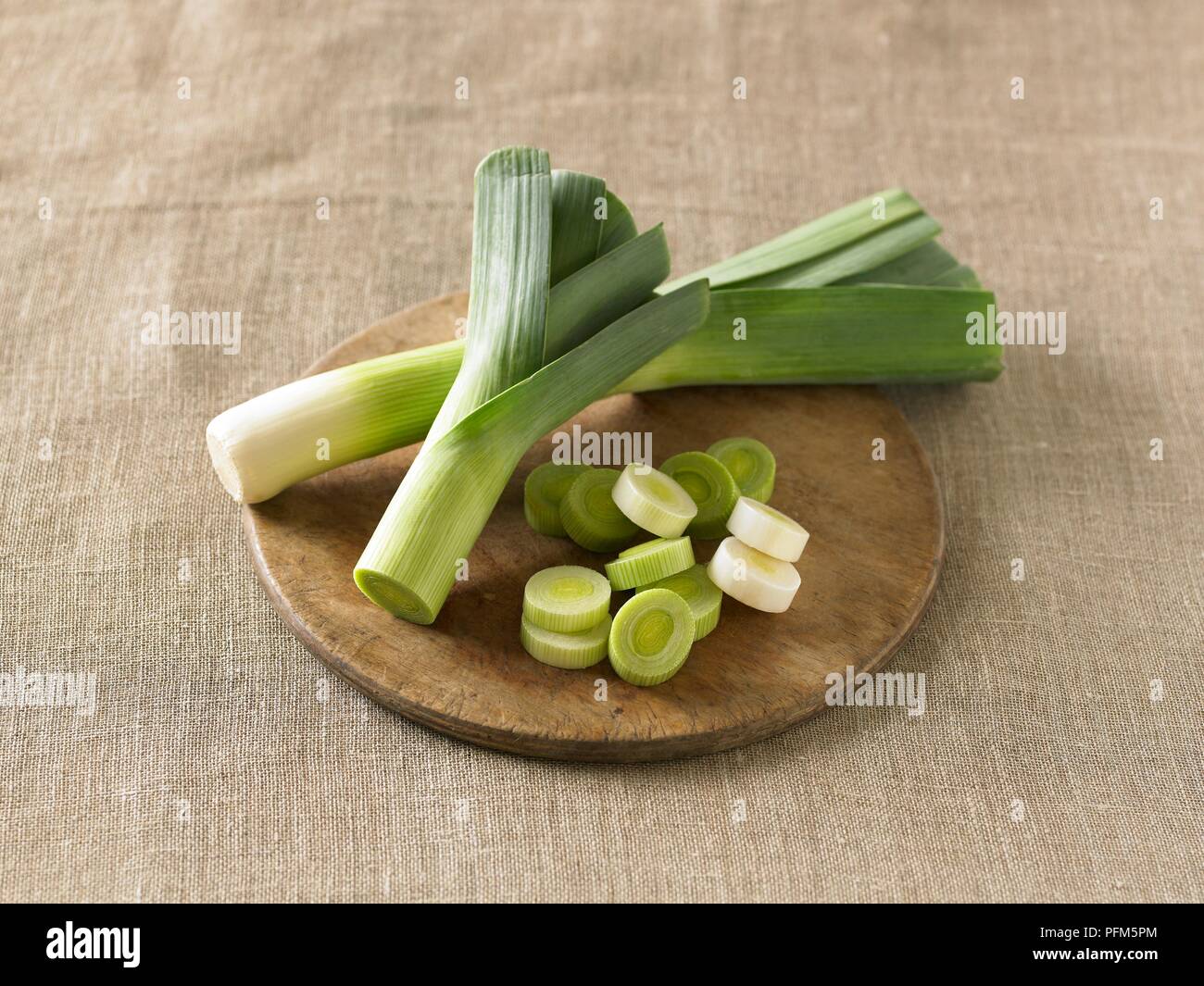 Whole and sliced leeks on chopping board Stock Photo - Alamy
