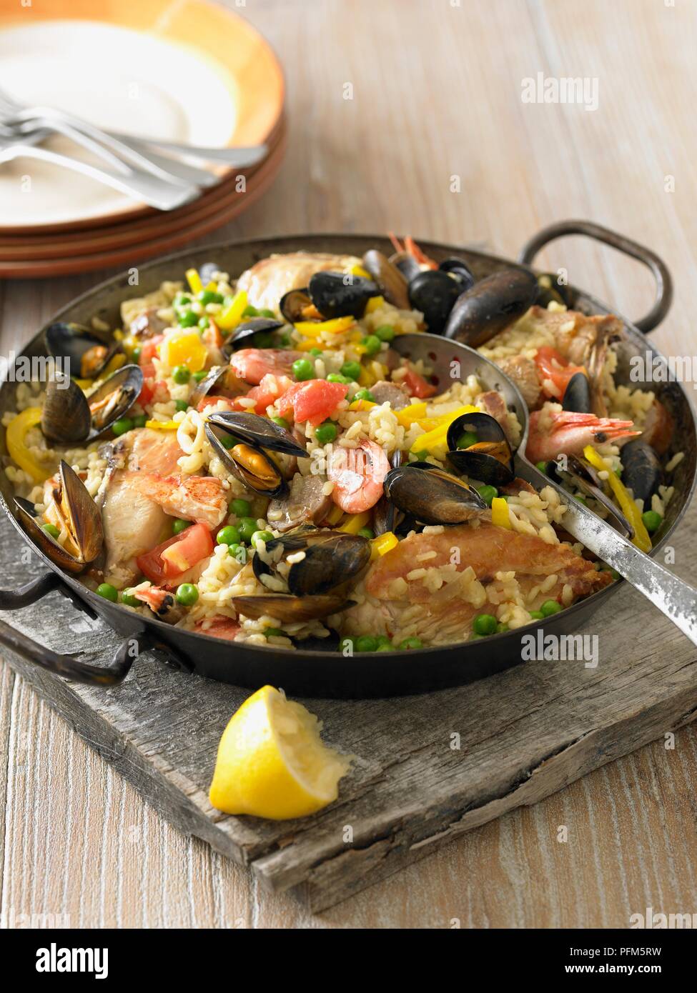 Dish of seafood paella on chopping board Stock Photo - Alamy