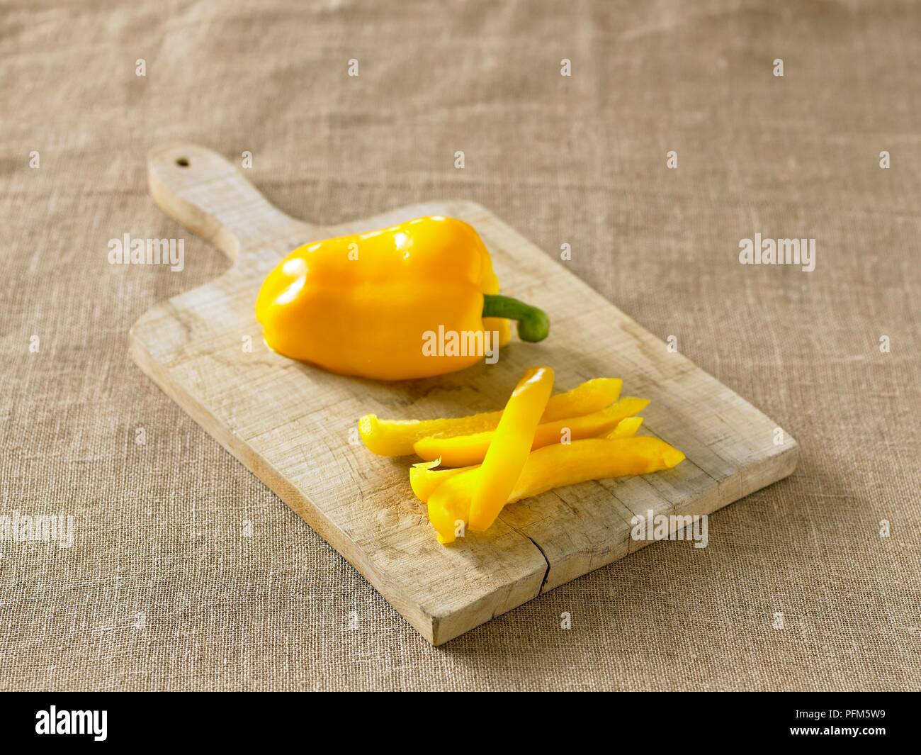 Yellow bell pepper cut into strips on chopping board Stock Photo - Alamy