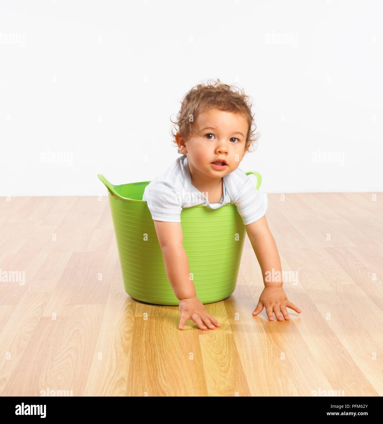 Baby boy inside plastic basket, hands on the floor Stock Photo - Alamy