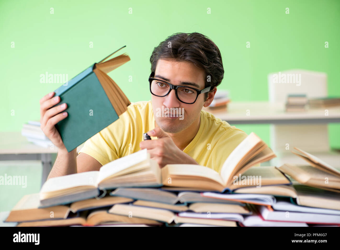 Student with too many books to read before exam Stock Photo - Alamy