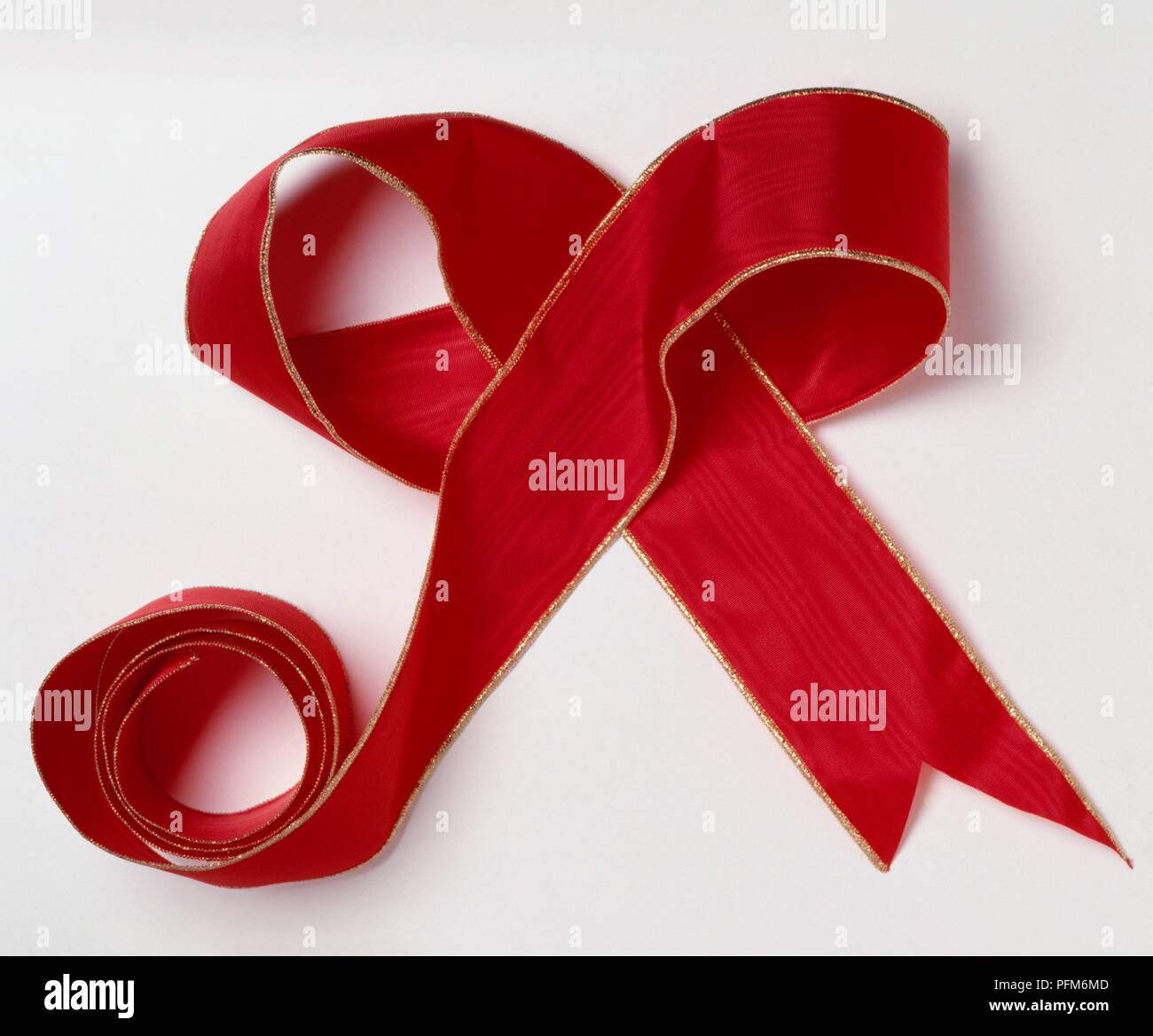 Red ribbon being tied into a bow Stock Photo - Alamy