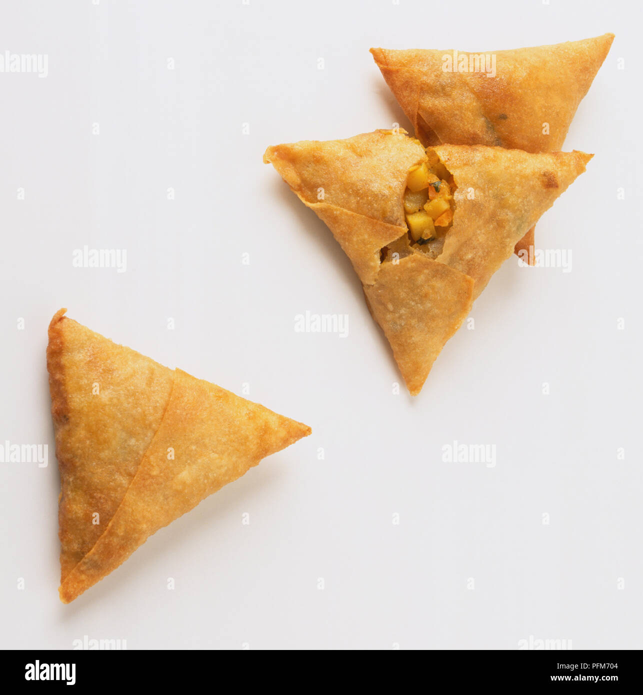 Three Samosas, one slightly cracked showing vegetable stuffing Stock ...
