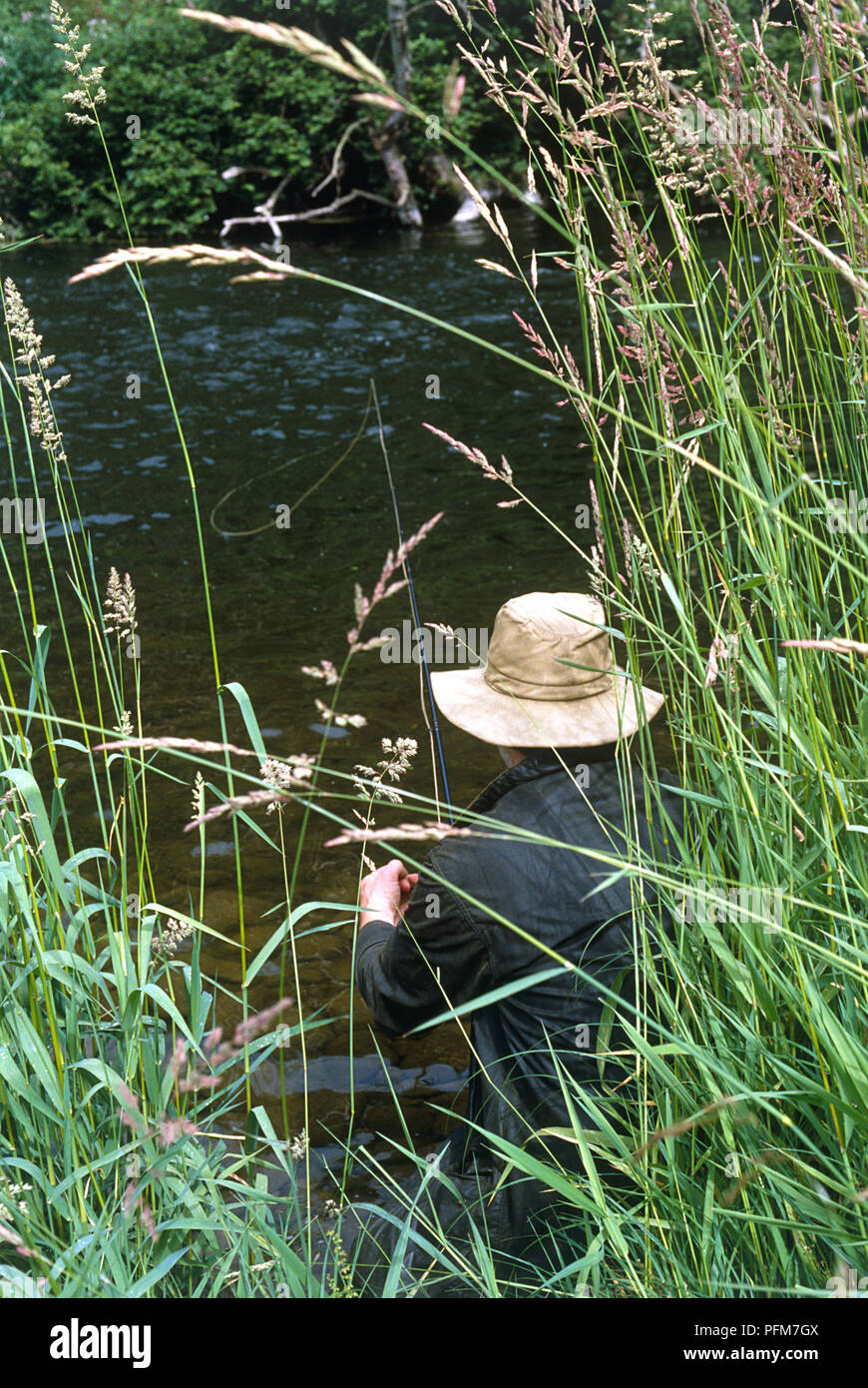 Great Britain, England, man fishing in a river, rear view Stock Photo ...