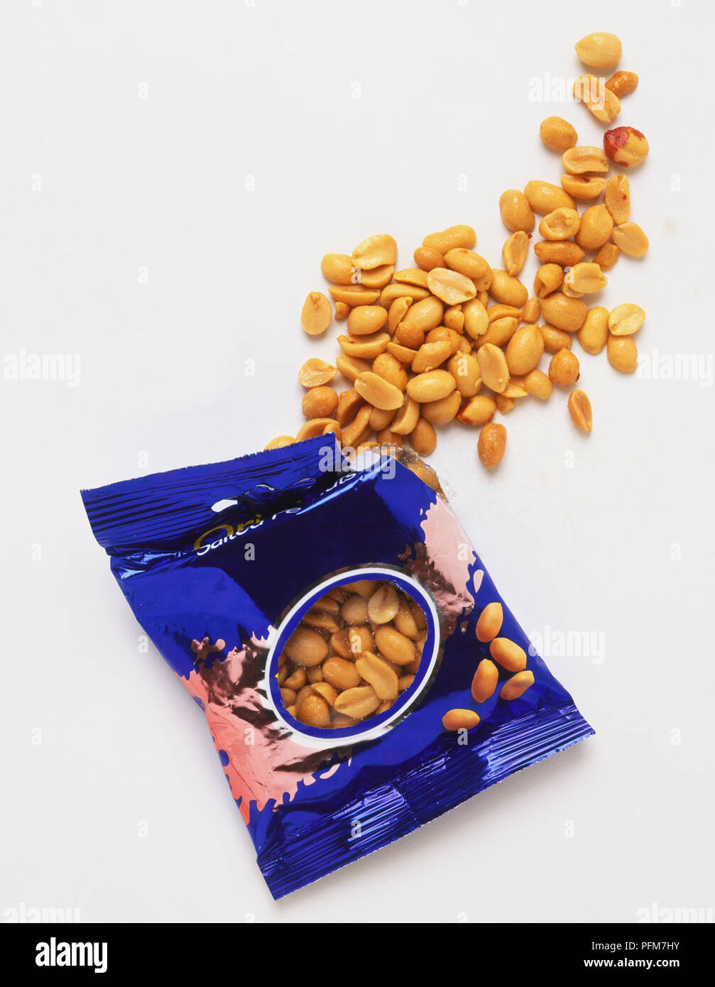 Peanuts spill out of an opened packet Stock Photo - Alamy