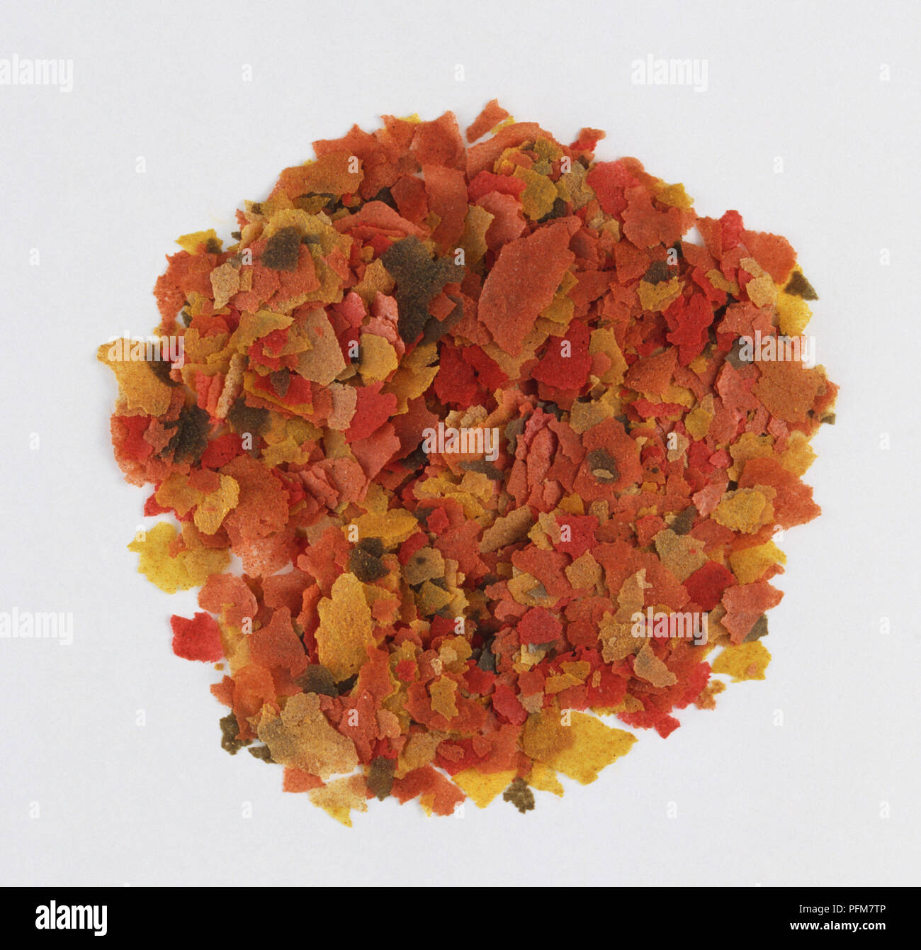 Reddish dry flakes, fish food Stock Photo - Alamy