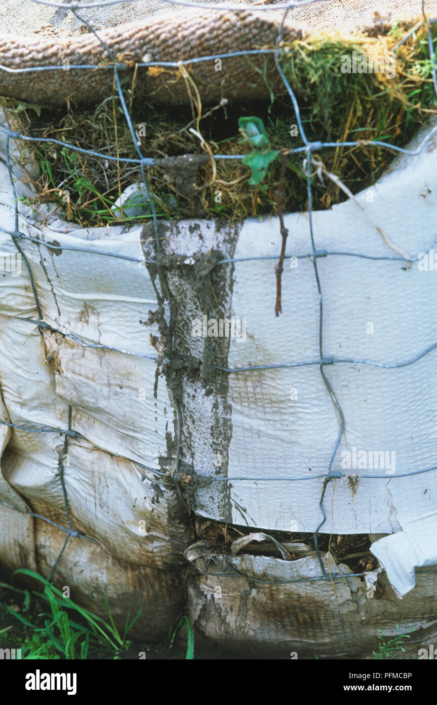 Compost heap surrounded with wire frame, side view Stock Photo - Alamy