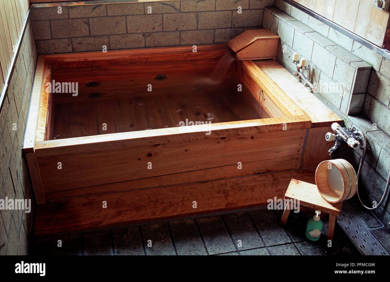 Communal bath and separate low shower in a traditional Japanese inn or ...