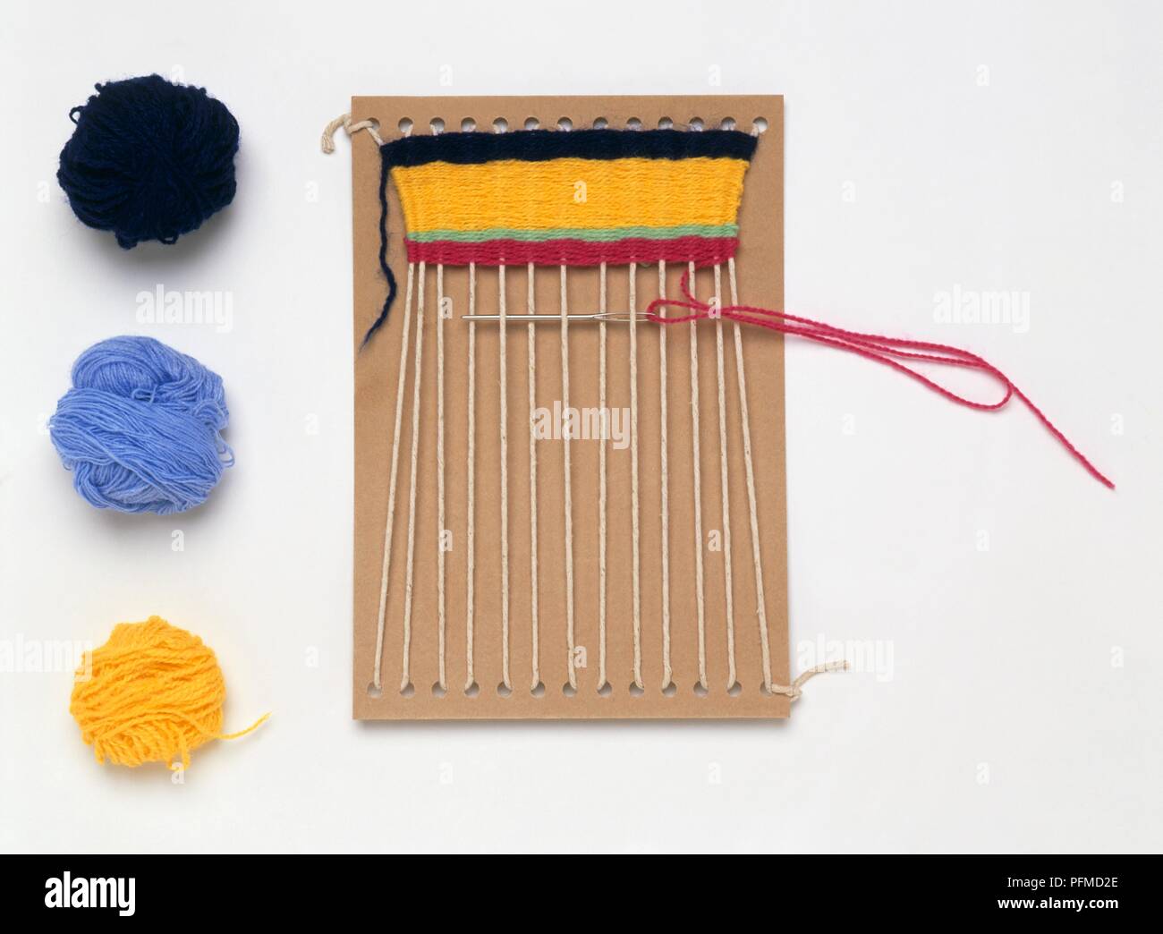 Weaving wool on simple loom using needle and thread Stock Photo - Alamy