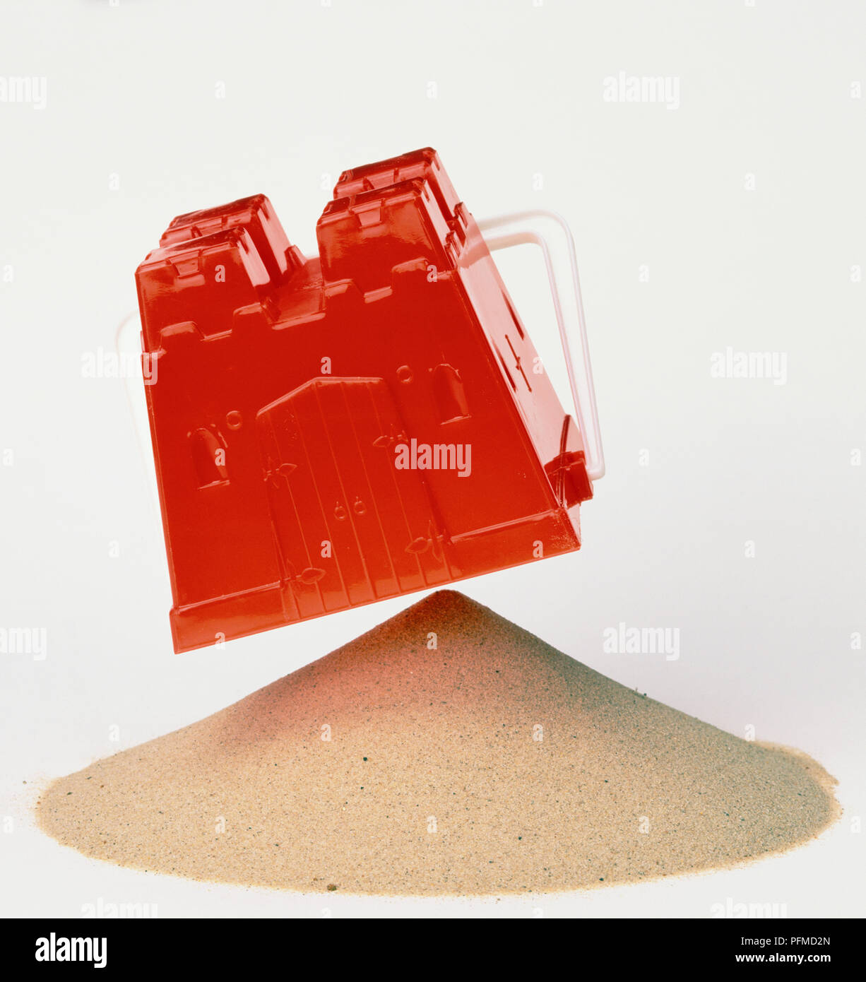 Castle shaped bucket suspended over a heap of dry sand Stock Photo - Alamy