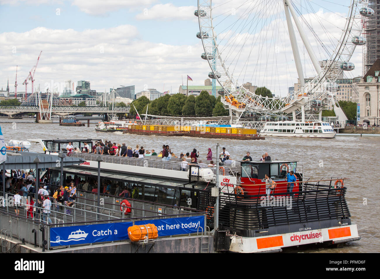 Tourist boats on the River Thames in London, with the London Eye and a ...