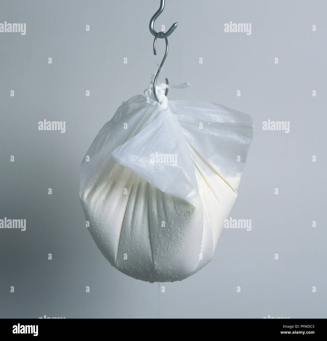 Milk curd draining in muslin bag hanging from hook Stock Photo - Alamy