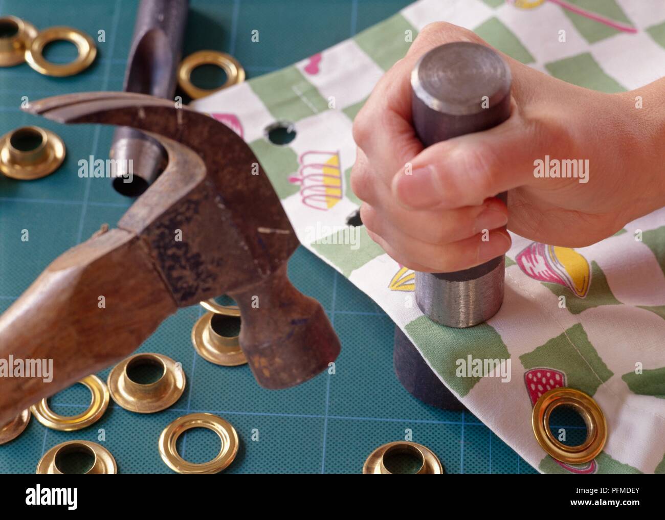 Using hole punch on curtain textiles Stock Photo - Alamy