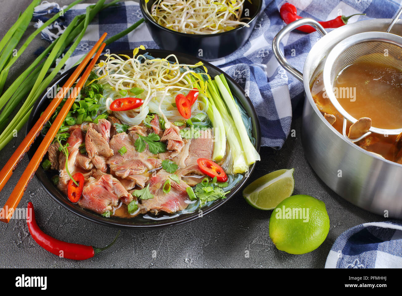 Vietnamese soup Pho Bo with rice noodle, raw sirloin beef slices, bean ...