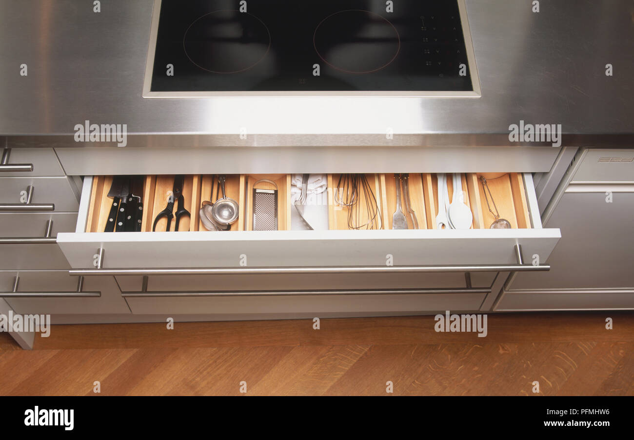 Pulled out drawer, underneath hob, showing kitchen utensils, view from ...