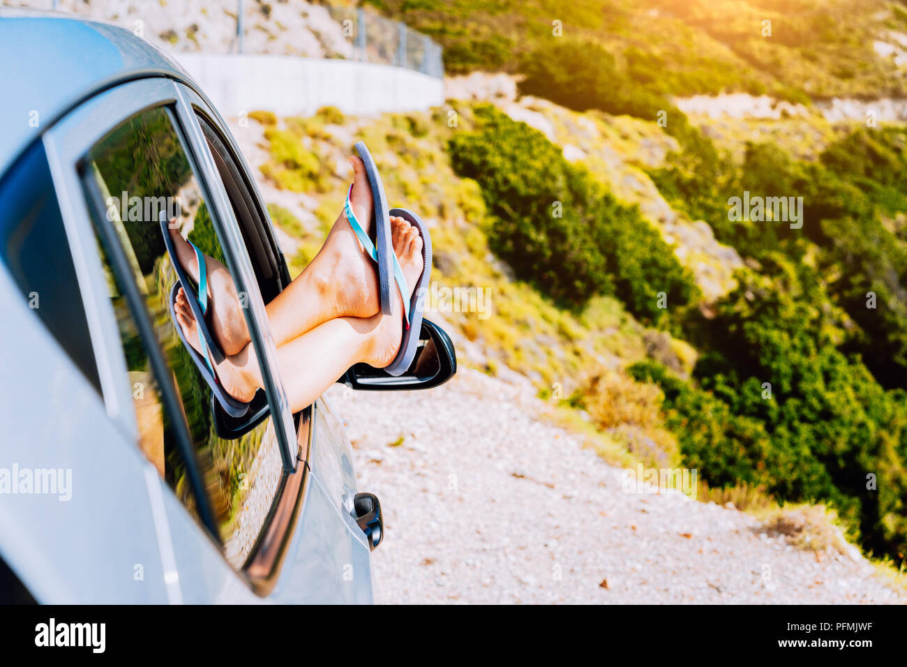 Summer road trip car vacation concept. Woman legs out the window in car ...