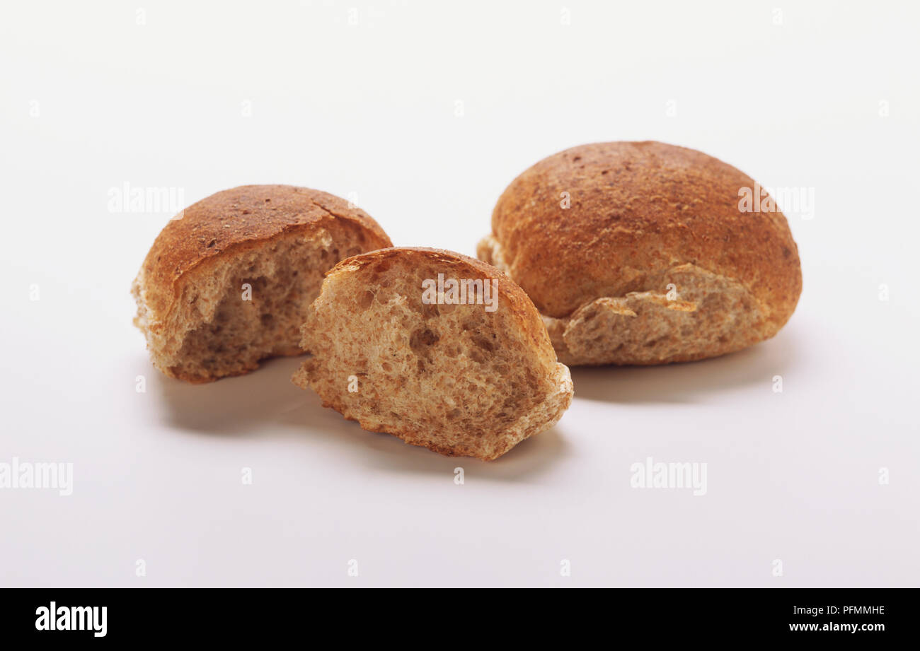 Whole and broken wholemeal bread rolls Stock Photo - Alamy