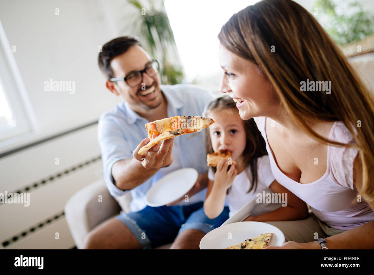 Happy family sharing pizza together at home Stock Photo - Alamy