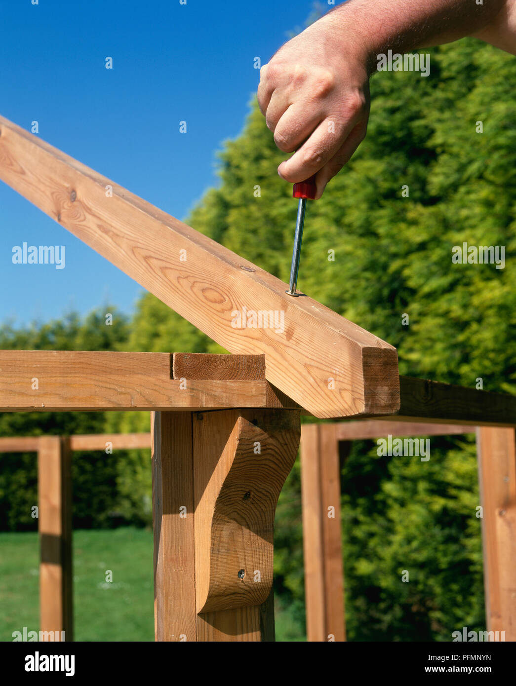 Securing ends of the rafters to roof support frame with long screws ...