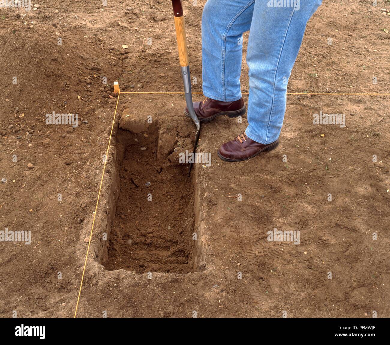 Person digging with spade in area marked-out with string Stock Photo ...
