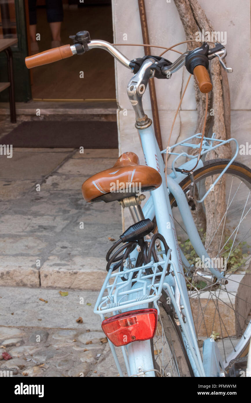an old style vintage bicycle painted light blue with a leather saddle ...