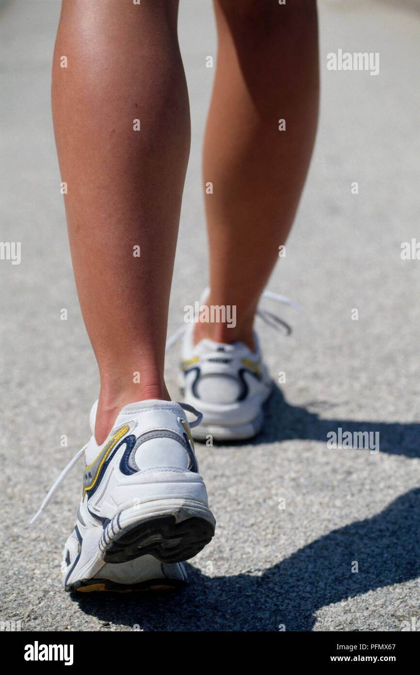 Woman wearing trainers walking on path Stock Photo - Alamy