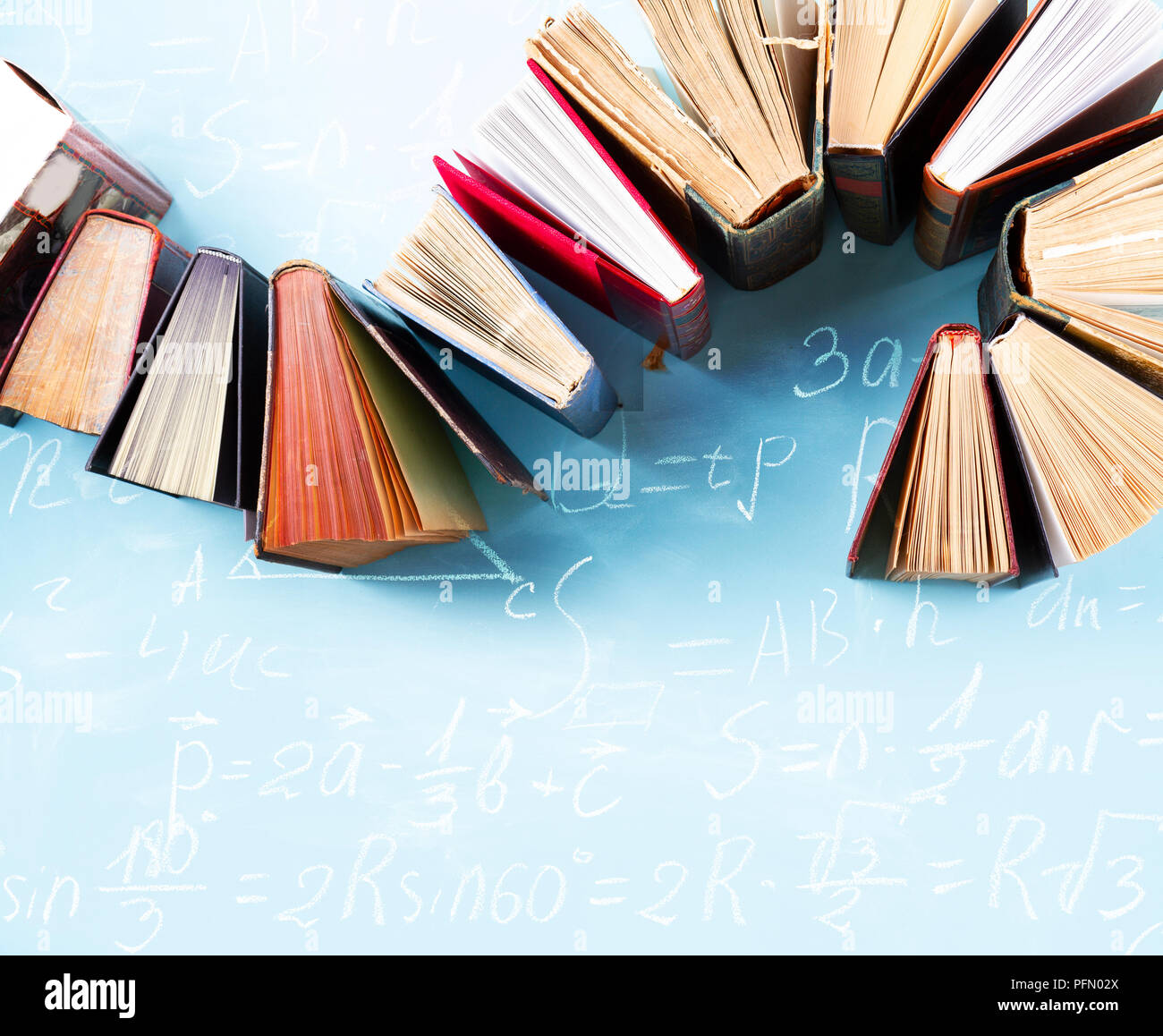 Curve of old books on blue background with math formuas, back to school ...