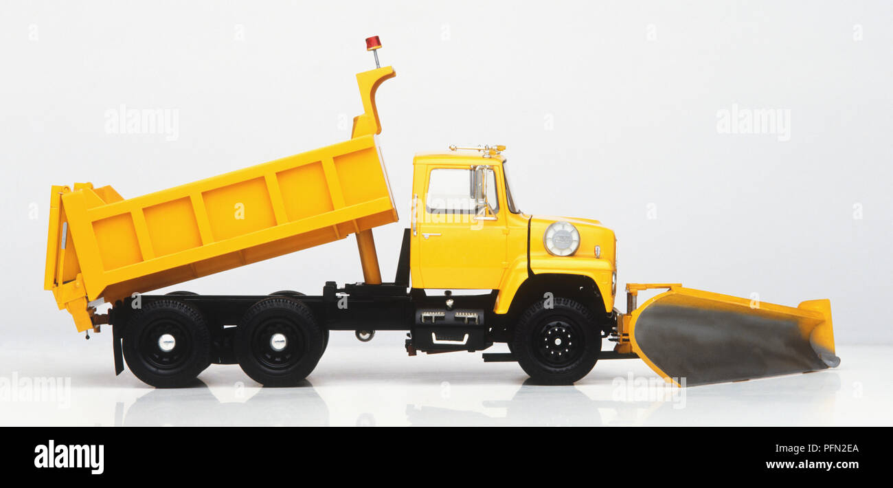 Yellow toy plough truck with back raised, side view Stock Photo - Alamy