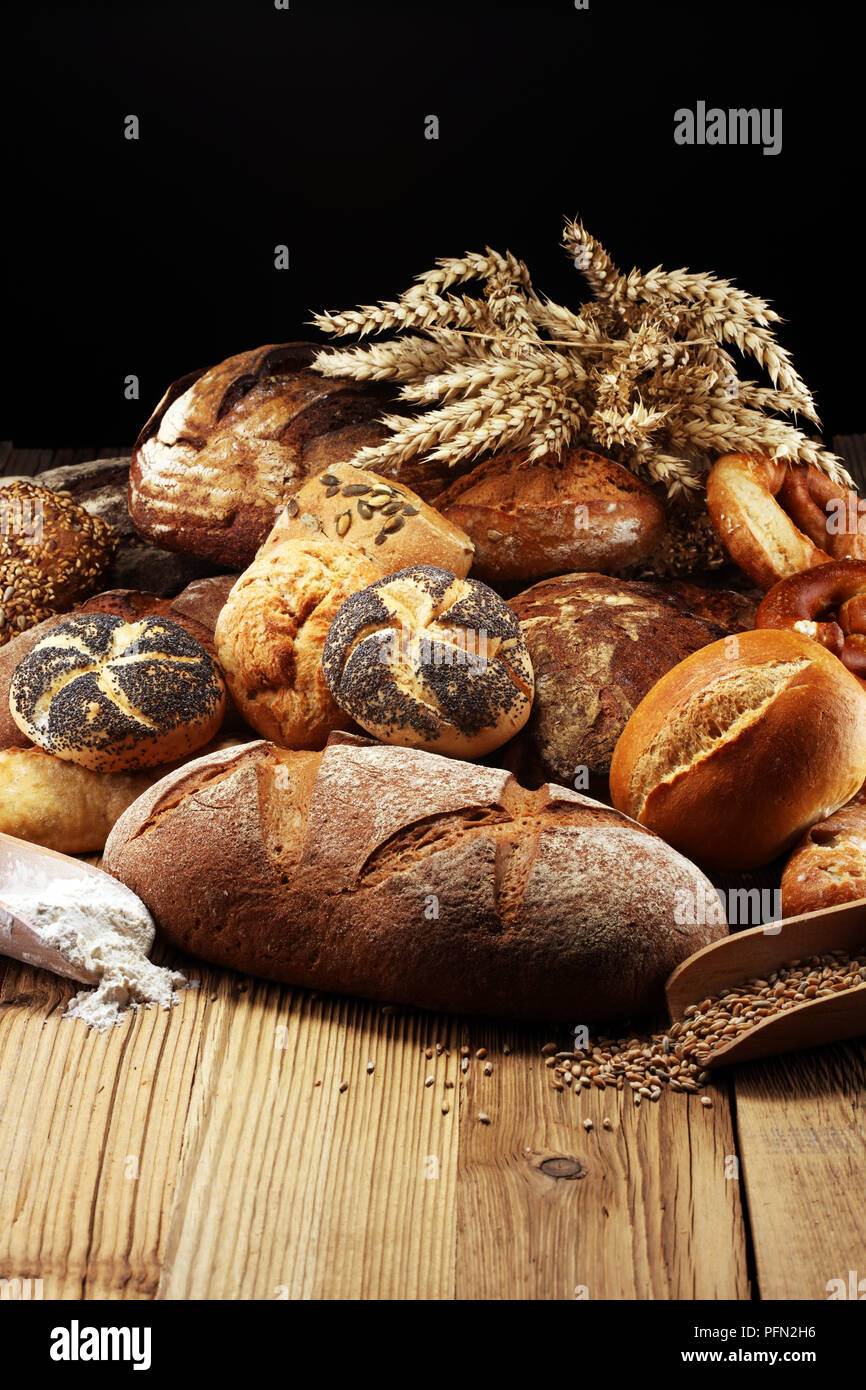 Different kinds of bread and bread rolls on board from above. Kitchen ...