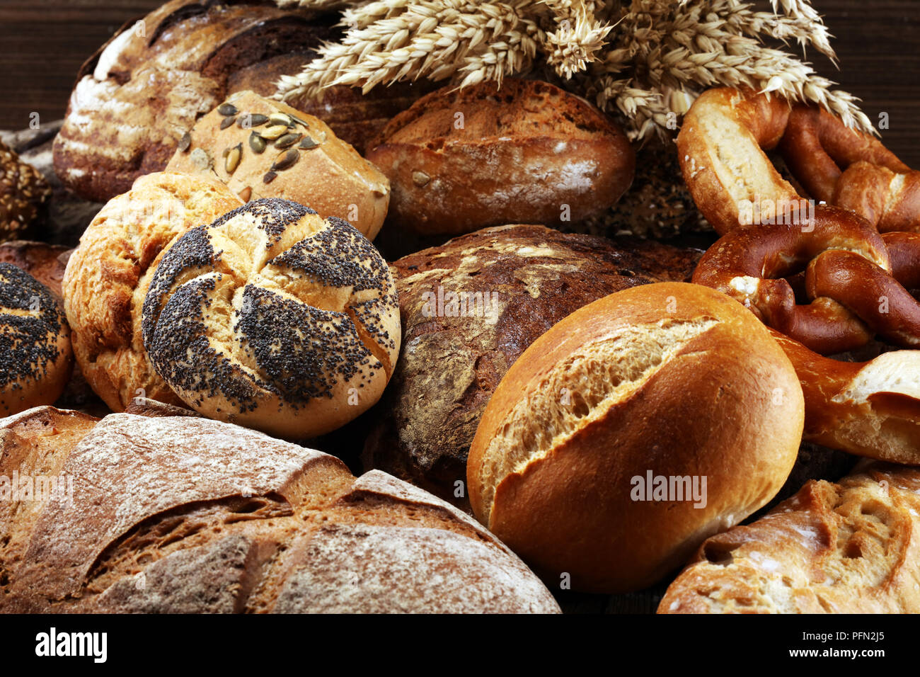 Different kinds of bread and bread rolls on board from above. Kitchen ...