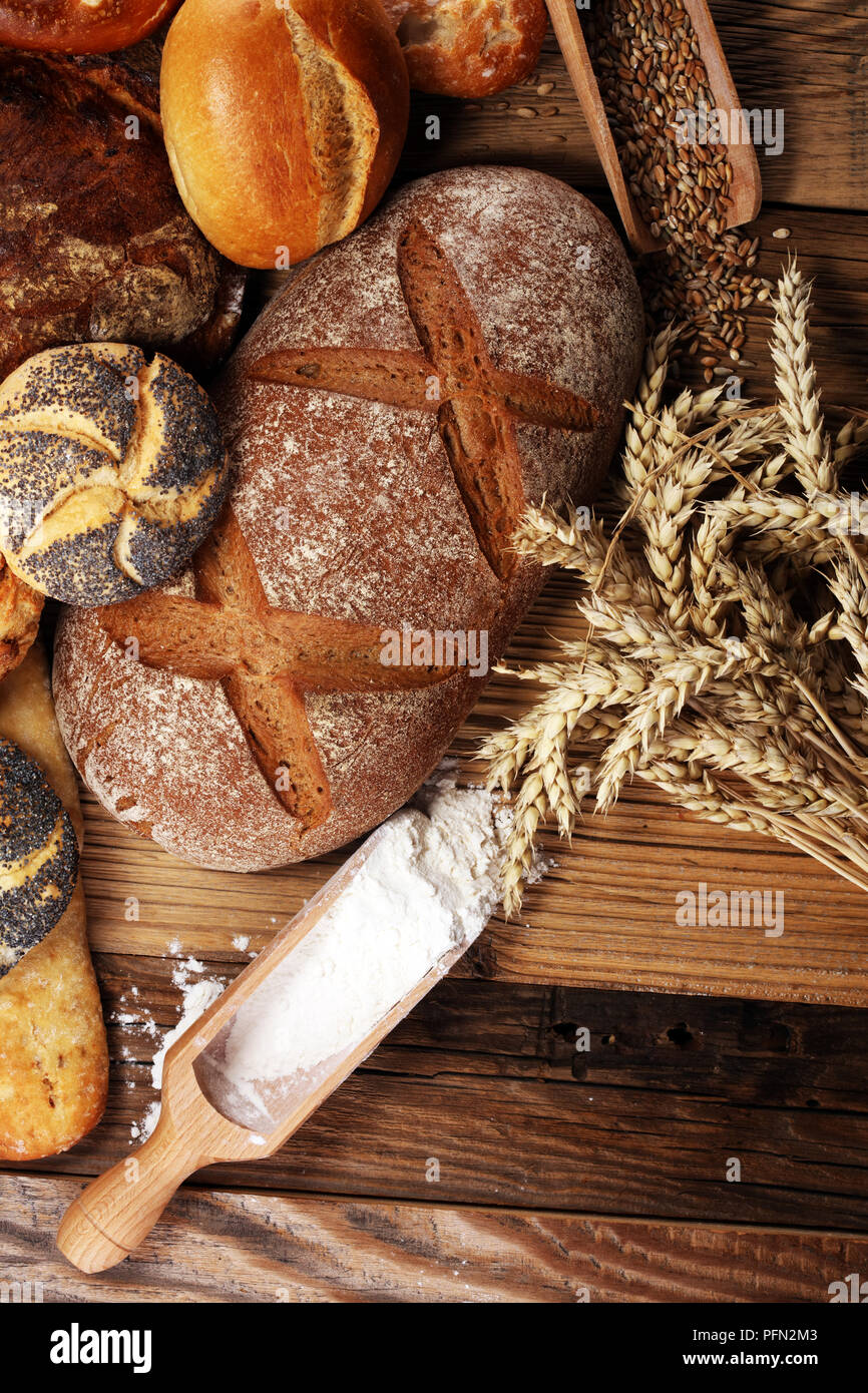Different kinds of bread and bread rolls on board from above. Kitchen ...