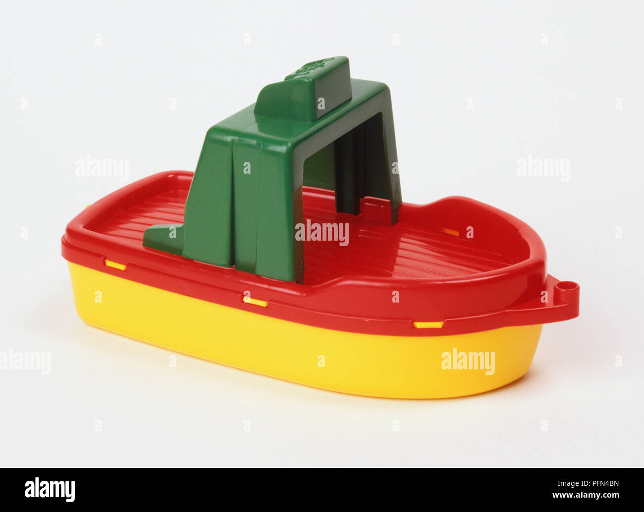 Yellow, red and green plastic toy boat Stock Photo - Alamy