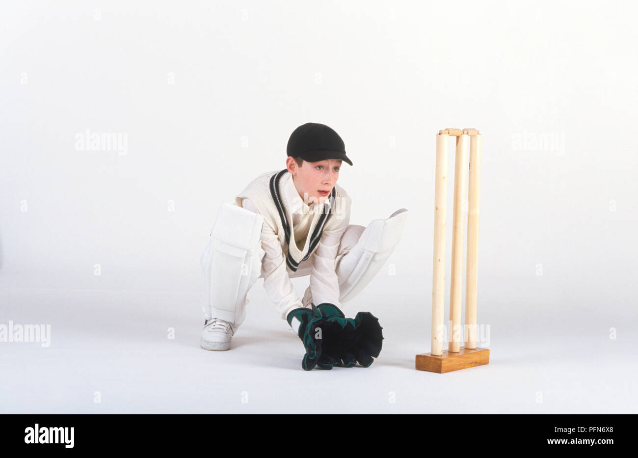 Young cricket player crouching behind wicket Stock Photo - Alamy