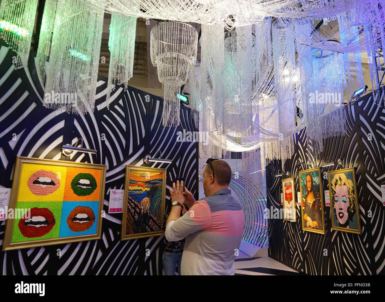 New York, USA. 21st Aug, 2018. A visitor takes photos of artworks made ...