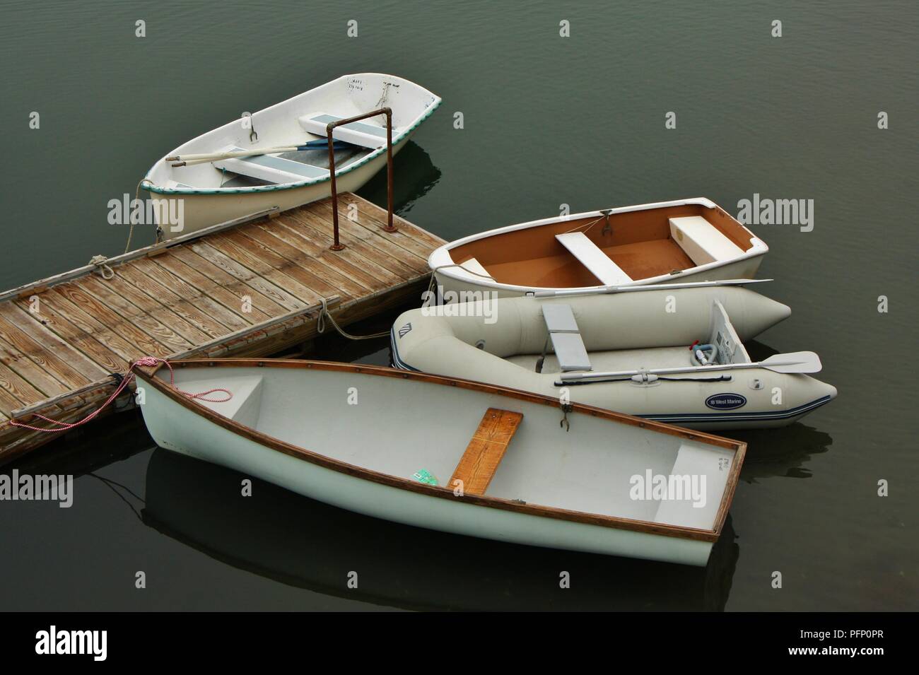 Empty rowboats clustered at dock on a foggy day in the Northeast Harbor ...